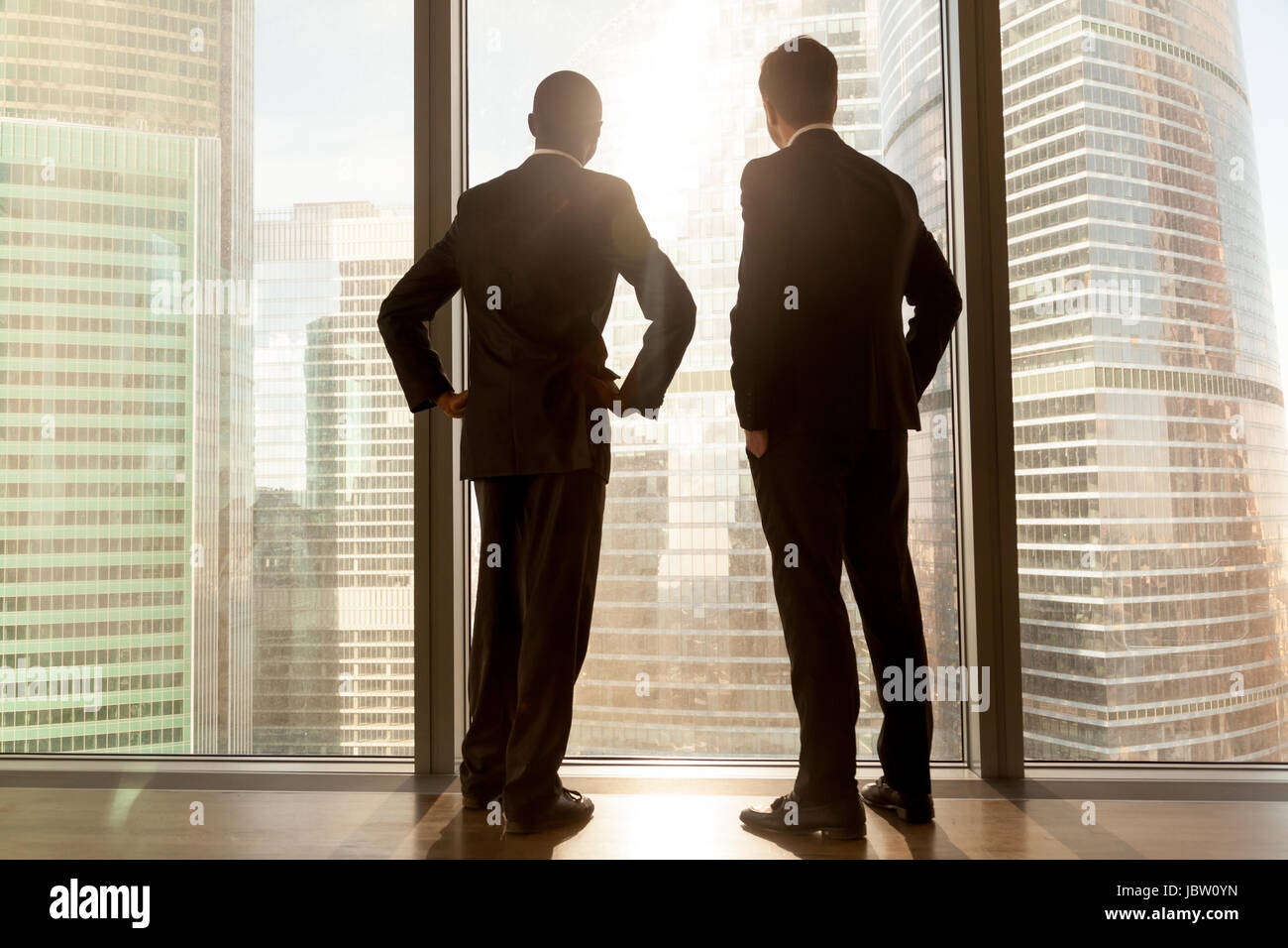 Rear view of african and caucasian businessmen wearing suits standing ...
