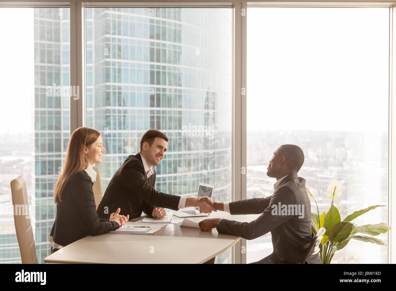 Friendly caucasian employers and confident african-american applicant ...