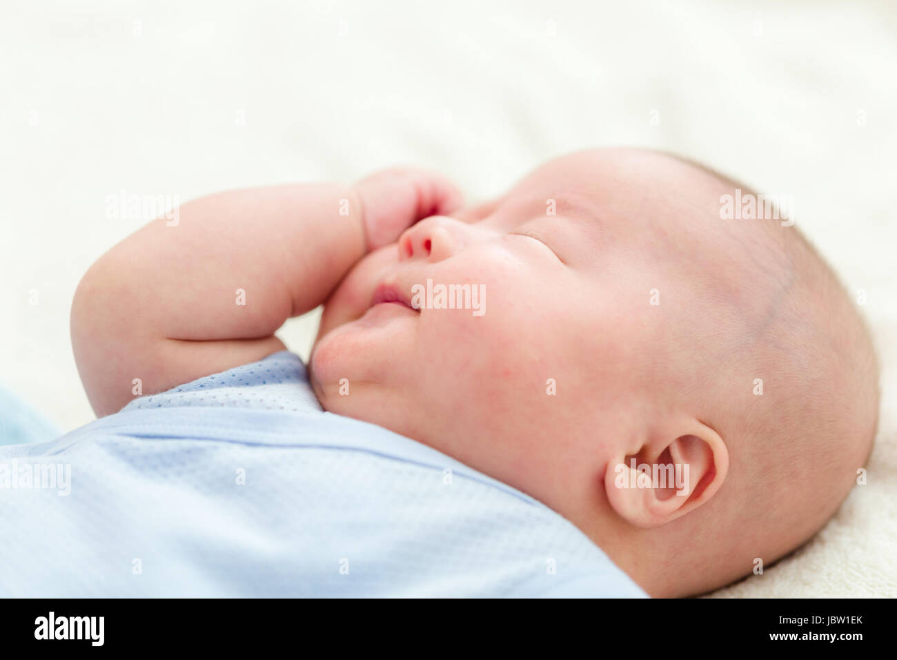 New born baby hand touch face Stock Photo - Alamy
