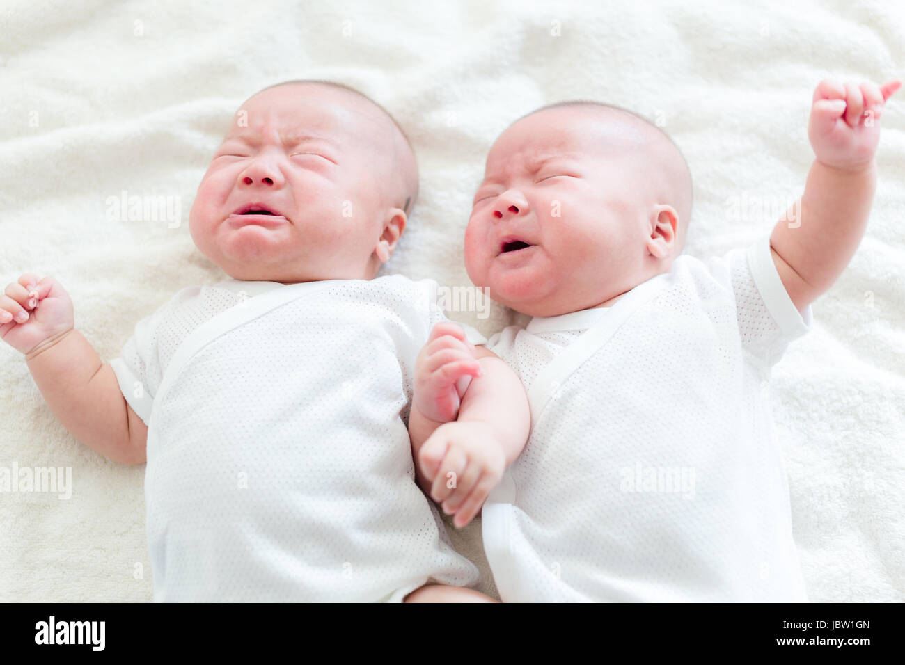 Baby twin cry Stock Photo - Alamy