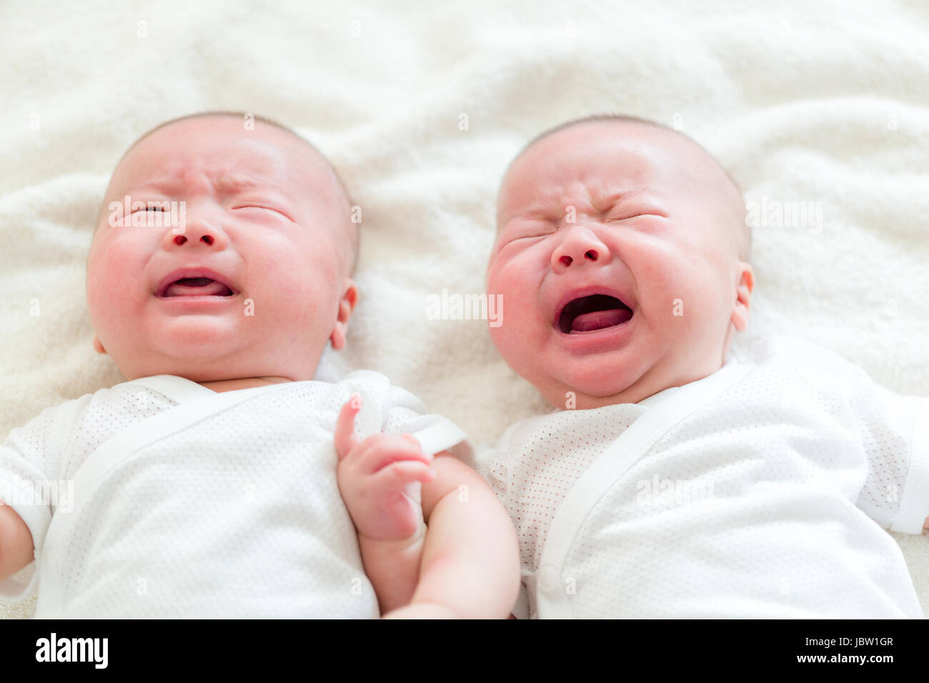 New born baby twins cry Stock Photo - Alamy