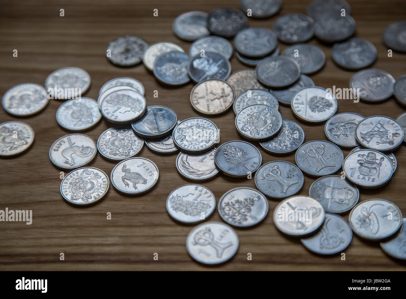 Anniversary lat coins of an old Latvian currency on a wooden background ...