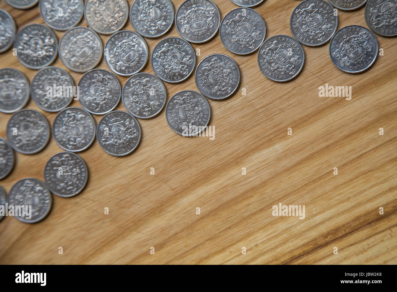 Anniversary lat coins of an old Latvian currency on a wooden background ...