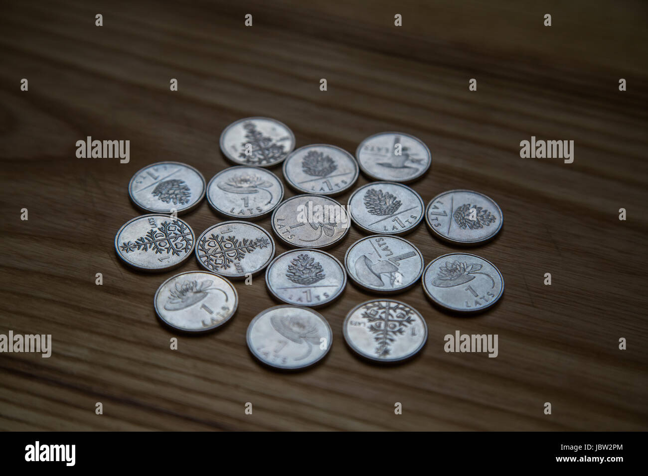 Anniversary lat coins of an old Latvian currency on a wooden background ...