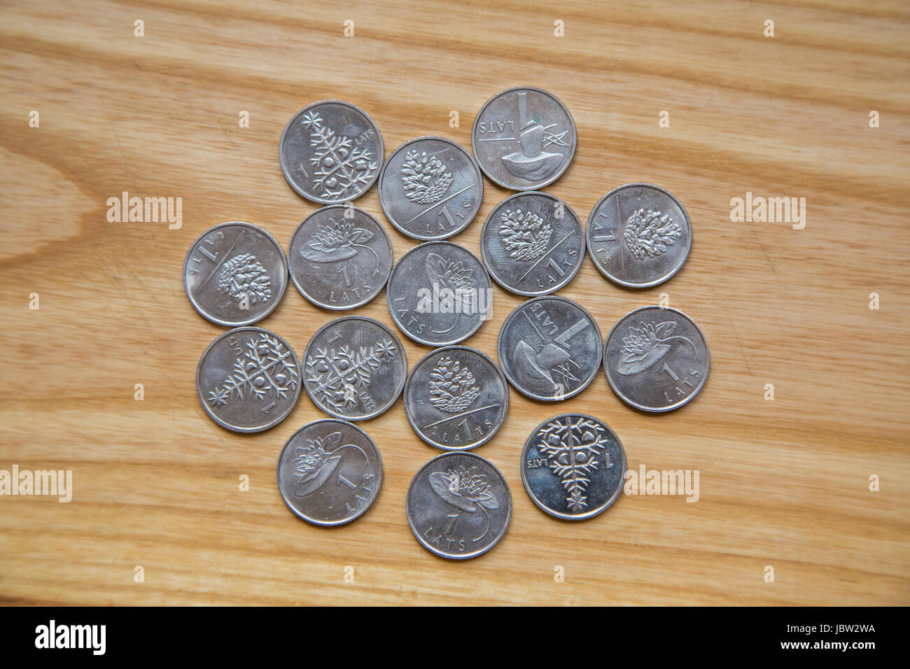 Anniversary lat coins of an old Latvian currency on a wooden background ...