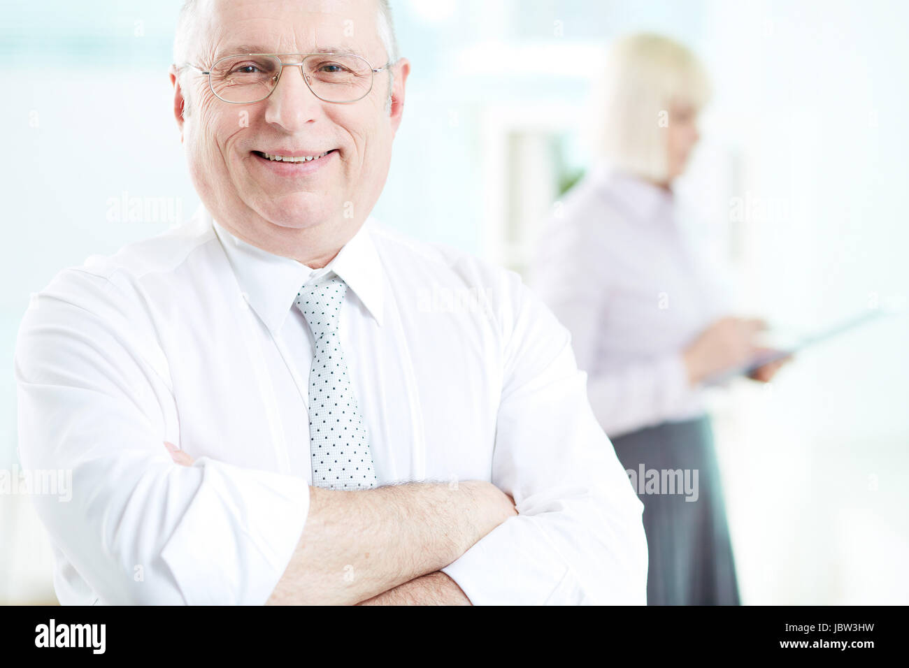 Portrait of smiling boss looking at camera with female standing on ...