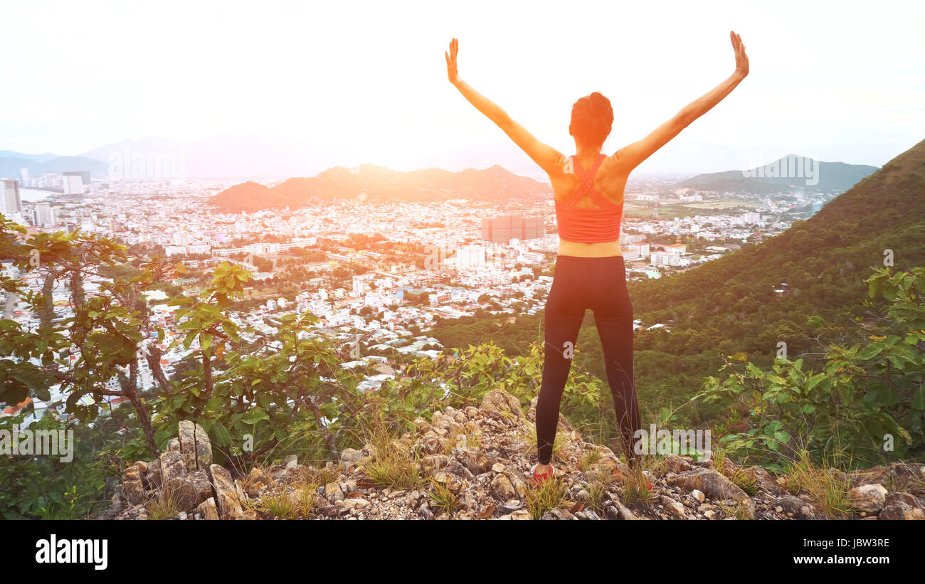 Woman runner raise hands up in the air. Female run on top of the ...