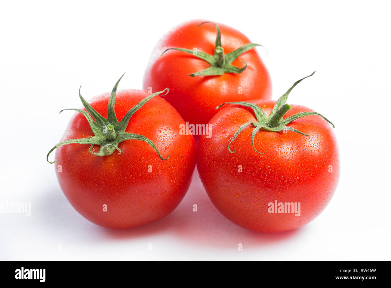Three red and ripe tomatoes on a white background Stock Photo - Alamy