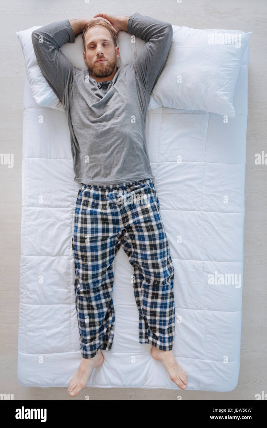 Pleasant bearded man lying on the bed Stock Photo - Alamy