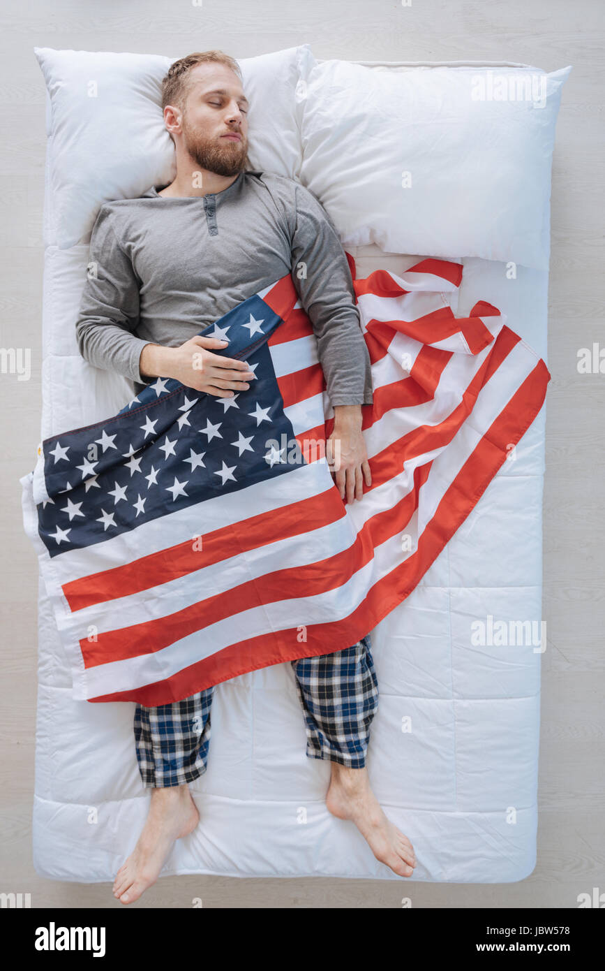 Handsome serious man holding the US flag Stock Photo - Alamy