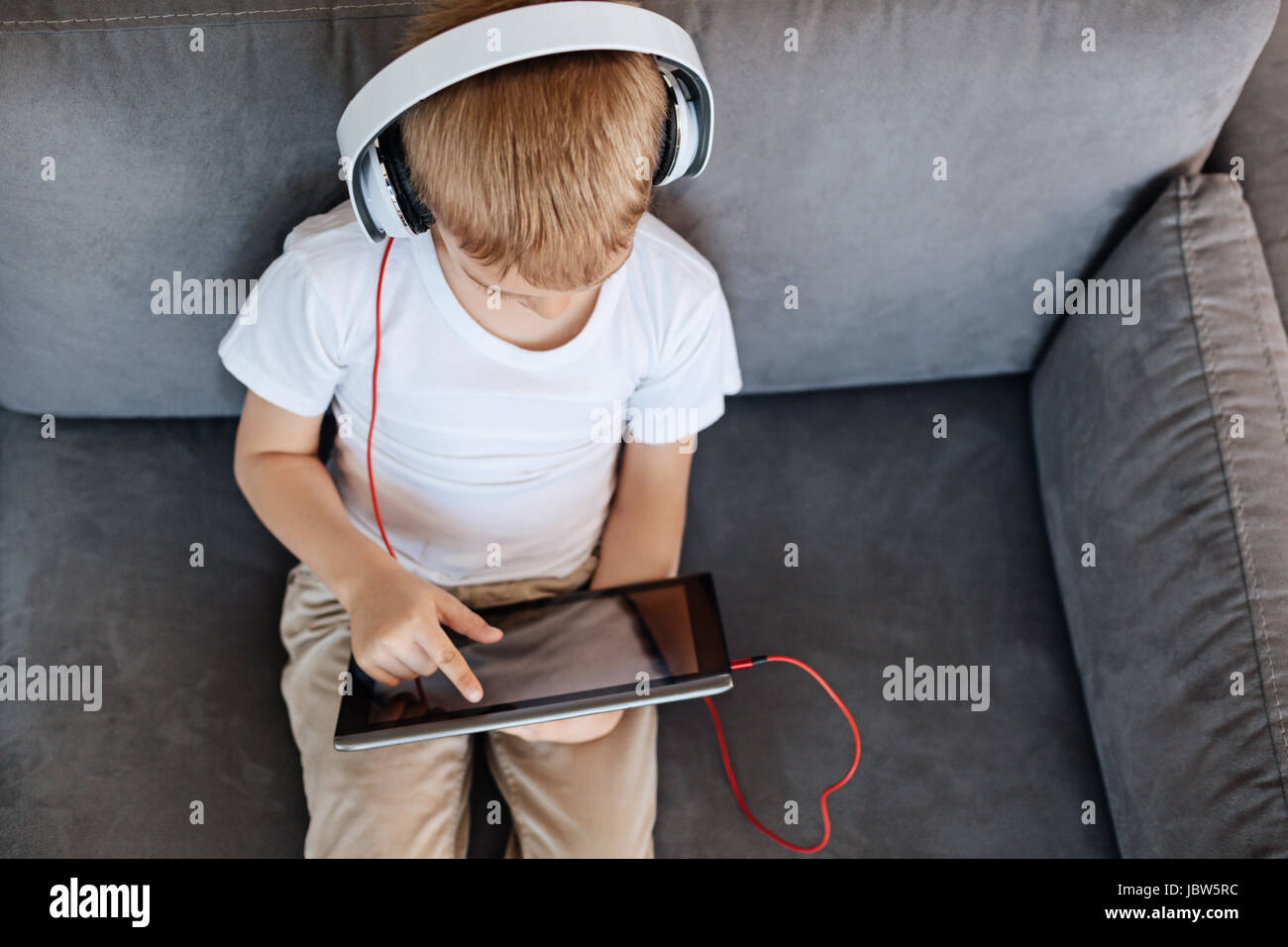 Lively focused kid using his tablet Stock Photo - Alamy