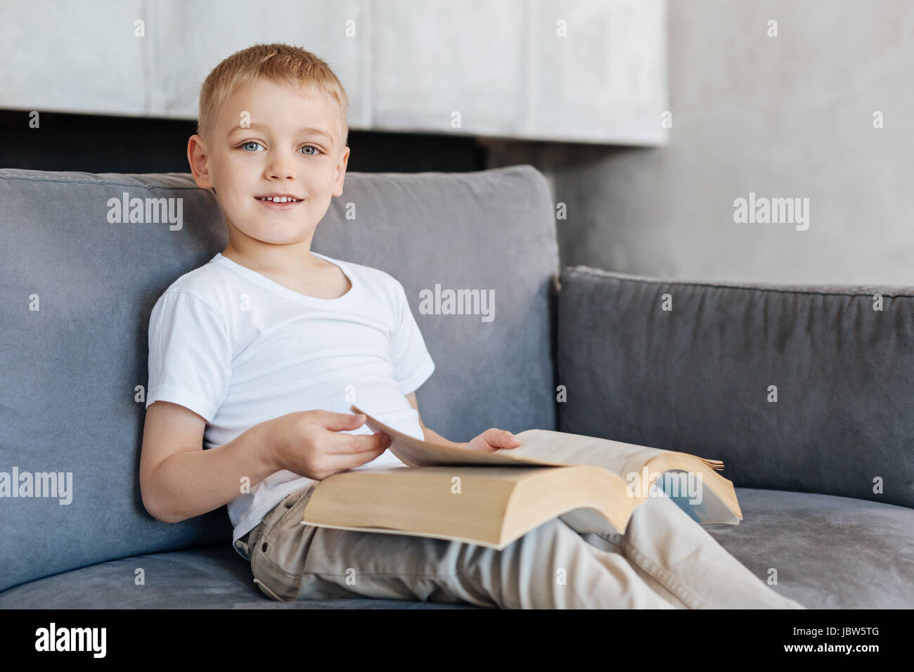 Intelligent lively child turning pages of a book Stock Photo - Alamy