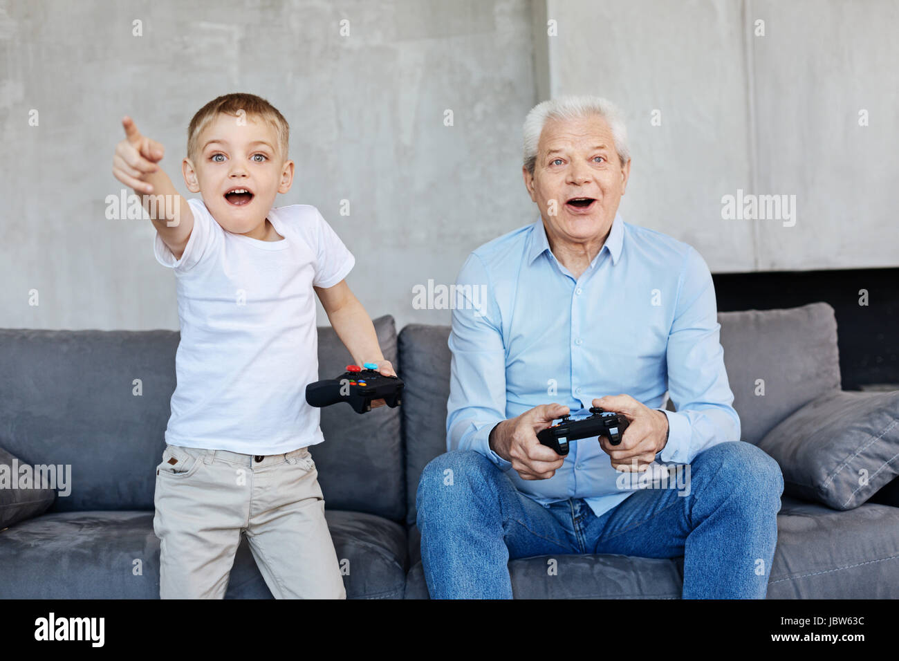 Kid and his grandpa playing video games together Stock Photo - Alamy