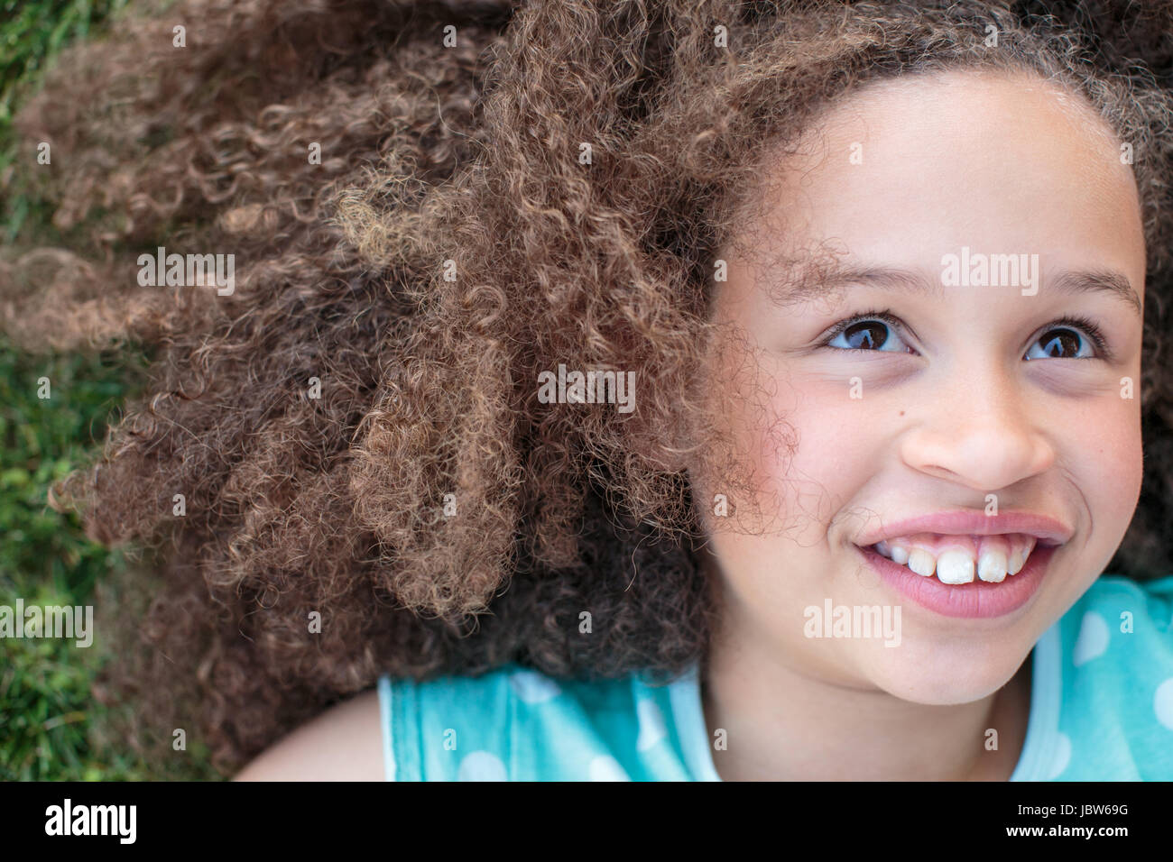 Portrait of girl, lying on grass, smiling, overhead view Stock Photo ...