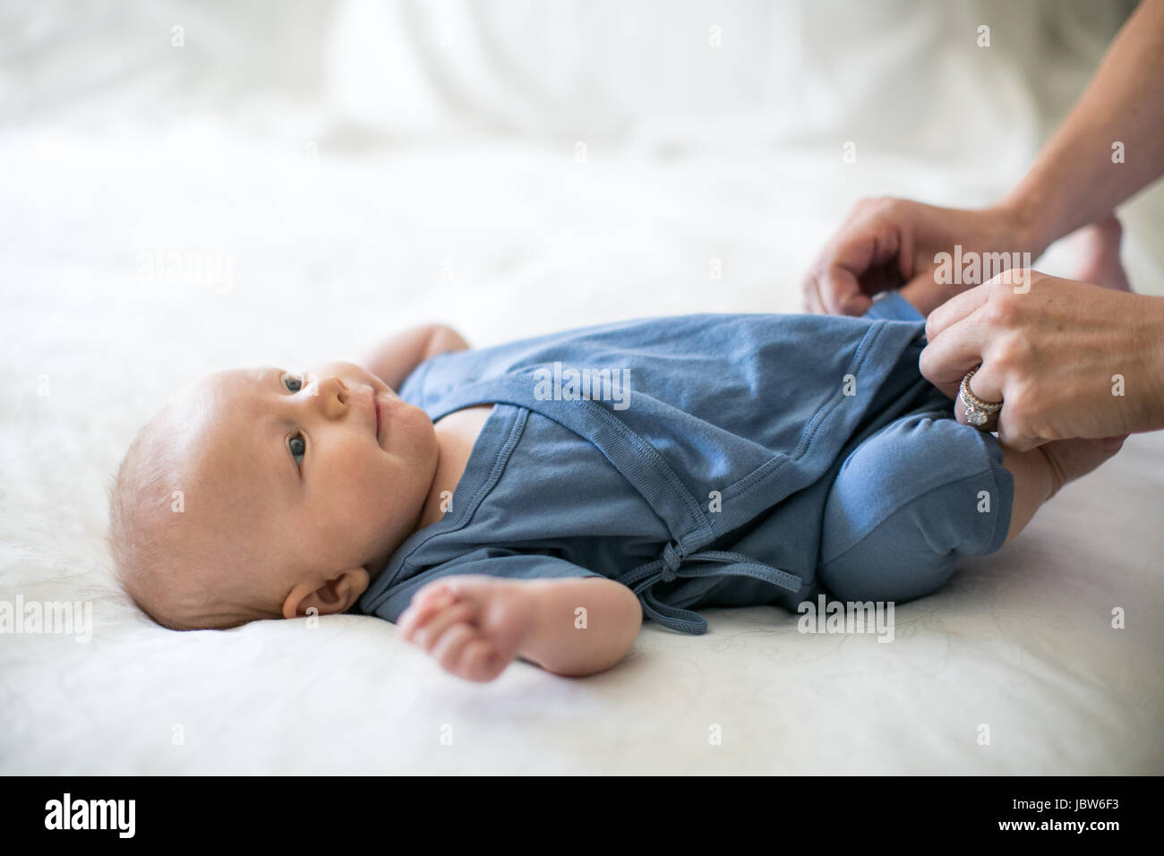 Mother dressing baby boy, close-up Stock Photo - Alamy