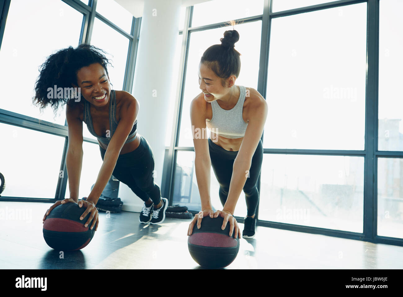 Two young women working out in gym, using gym equipment Stock Photo - Alamy