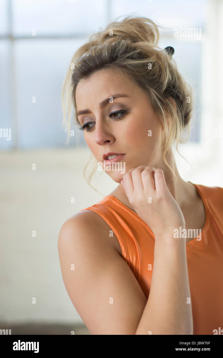 Beautiful young woman hand touching face looking away Stock Photo - Alamy