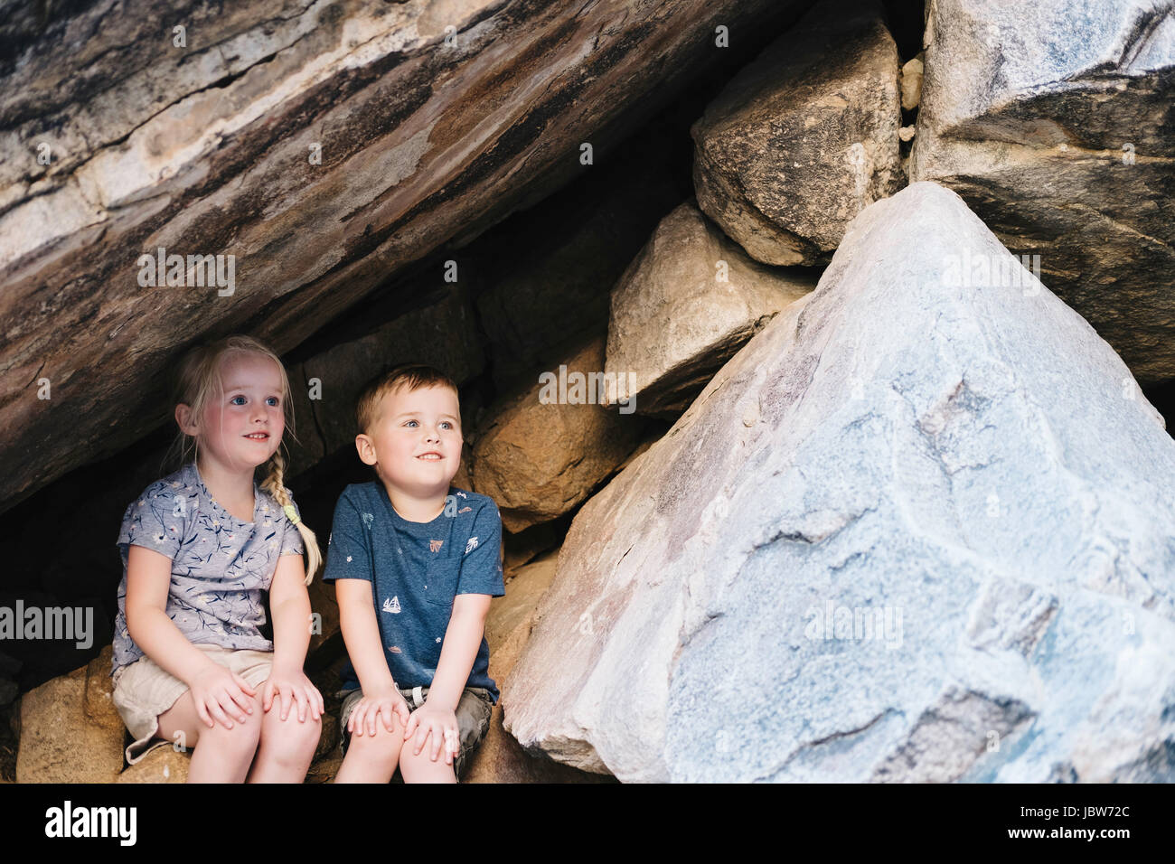 Boy girl sitting on rock hi-res stock photography and images - Alamy