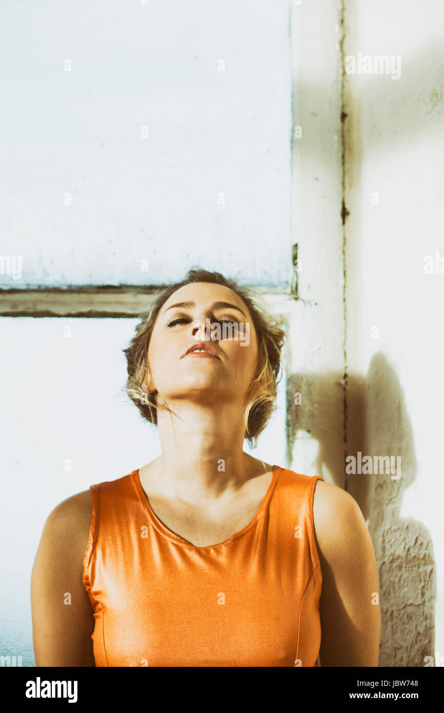 Beautiful young woman eyes closed by the window Stock Photo - Alamy