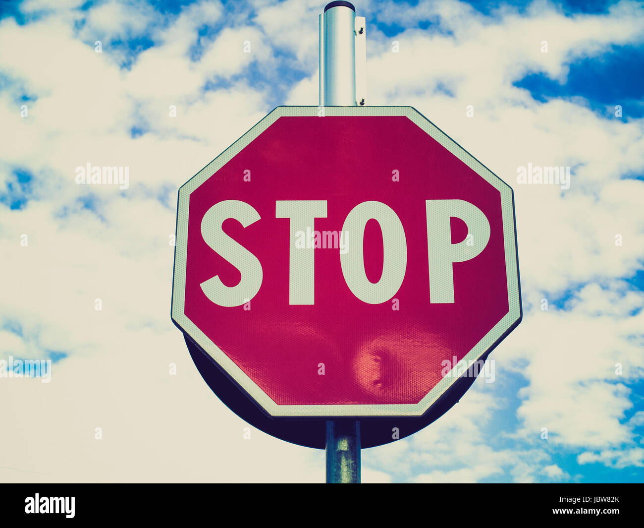 Vintage retro looking Stop traffic sign over blue sky with clouds Stock ...