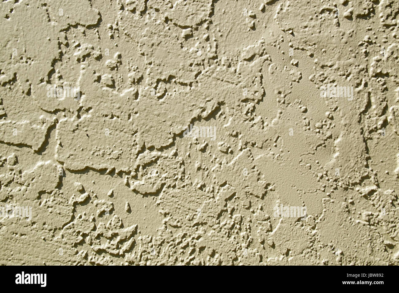 Close up of painted stucco wall outside in the sunshine with highlights ...