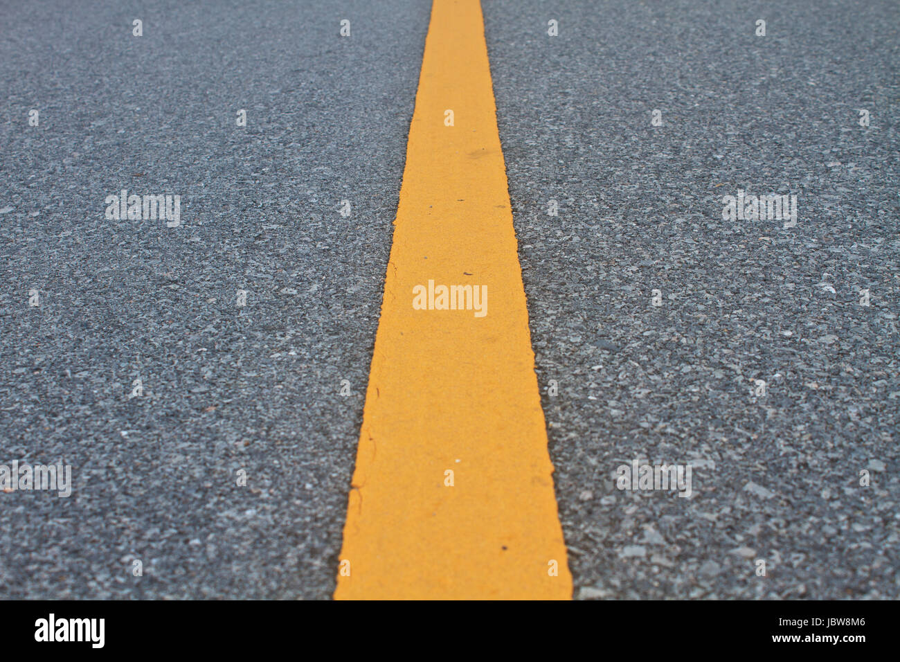asphalt road with marking lines and tire tracks. Close up photo with ...