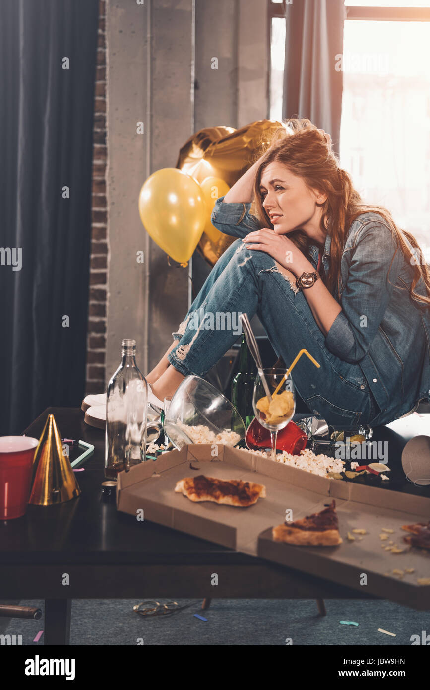 young woman with headache in messy room after party Stock Photo - Alamy