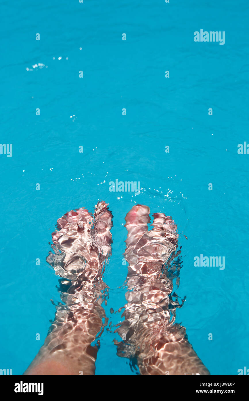 Splashing female feet in a swimming pool Stock Photo - Alamy