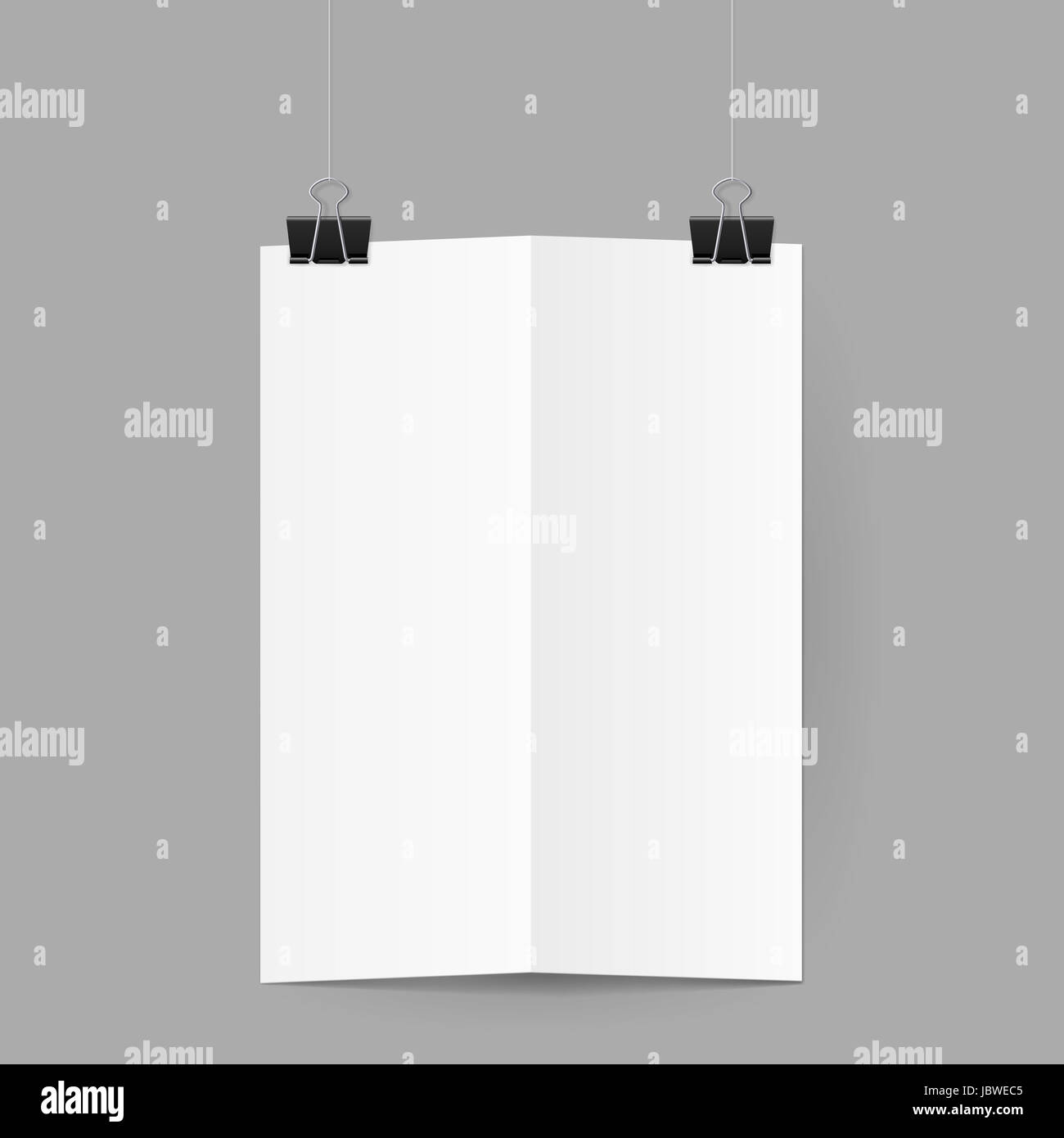 White sheet of paper folded in half. The paper hangs on black binder ...