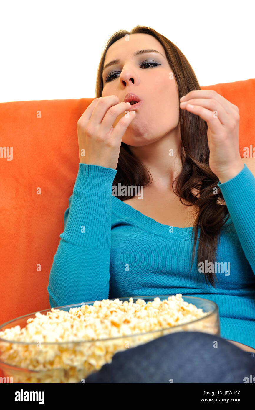 young woman eat popcorn, watching movies and eat popcorn at modern home ...