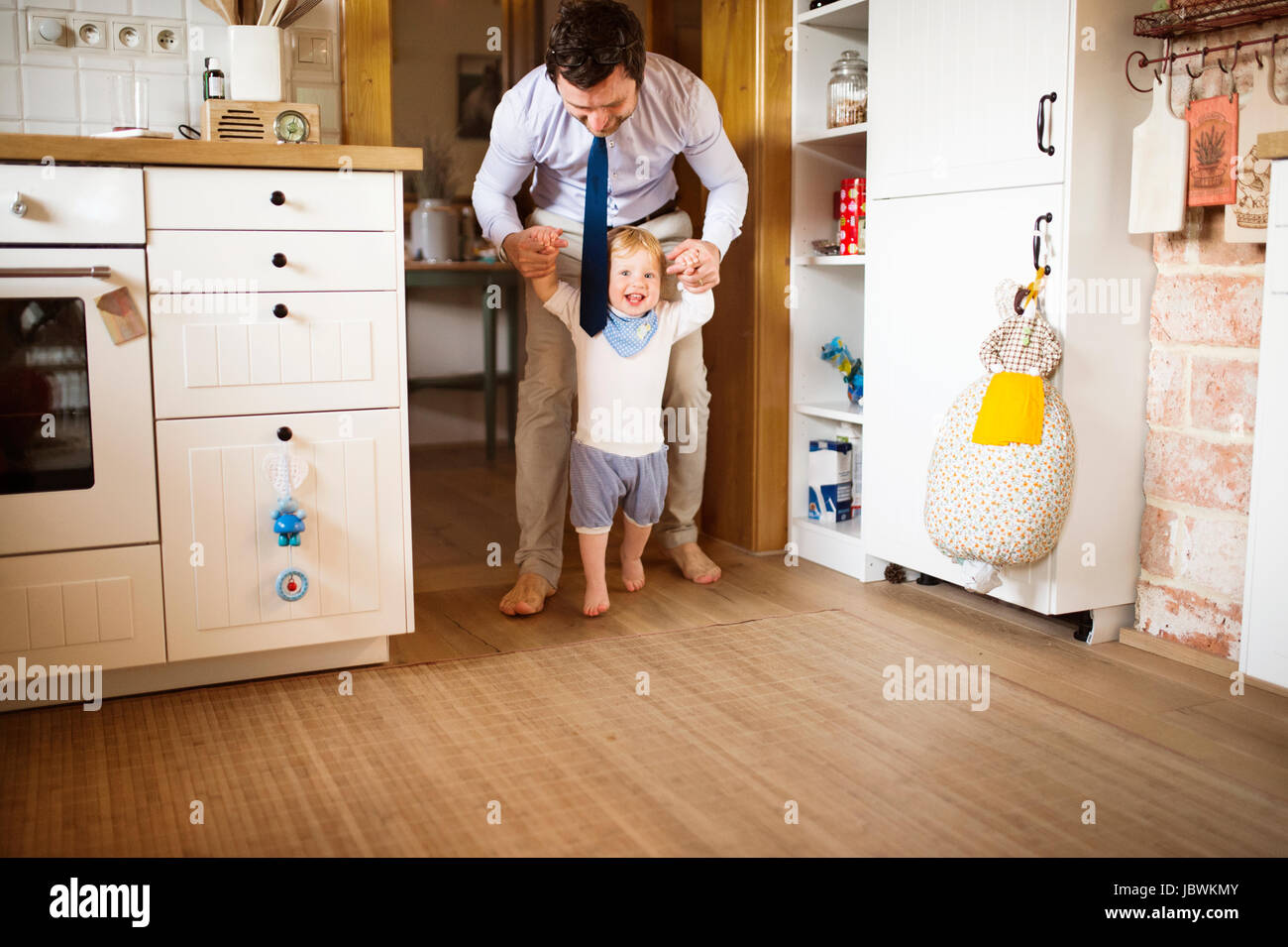 Young businessman holding hands of his son taking first steps Stock ...