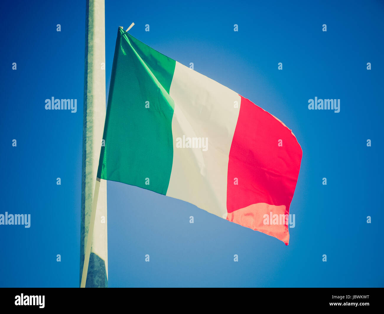 Vintage retro looking Flag of Italy over blue sky background Stock ...