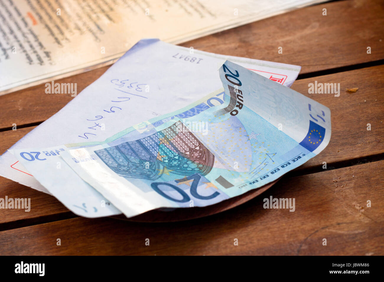 Dining check with Euro banknotes on wooden table Stock Photo - Alamy