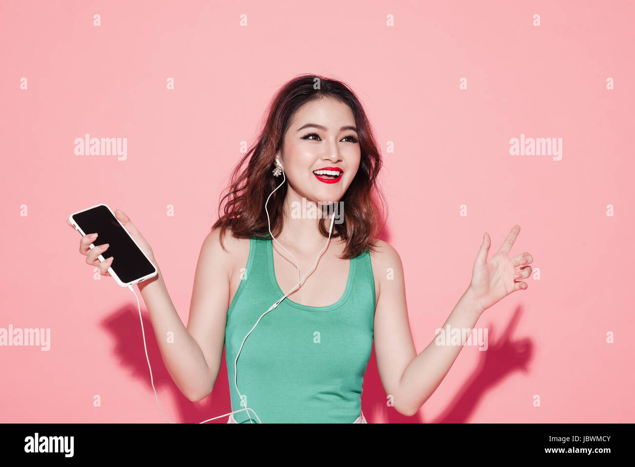 Young attractive asian woman with professional makeup singing and ...