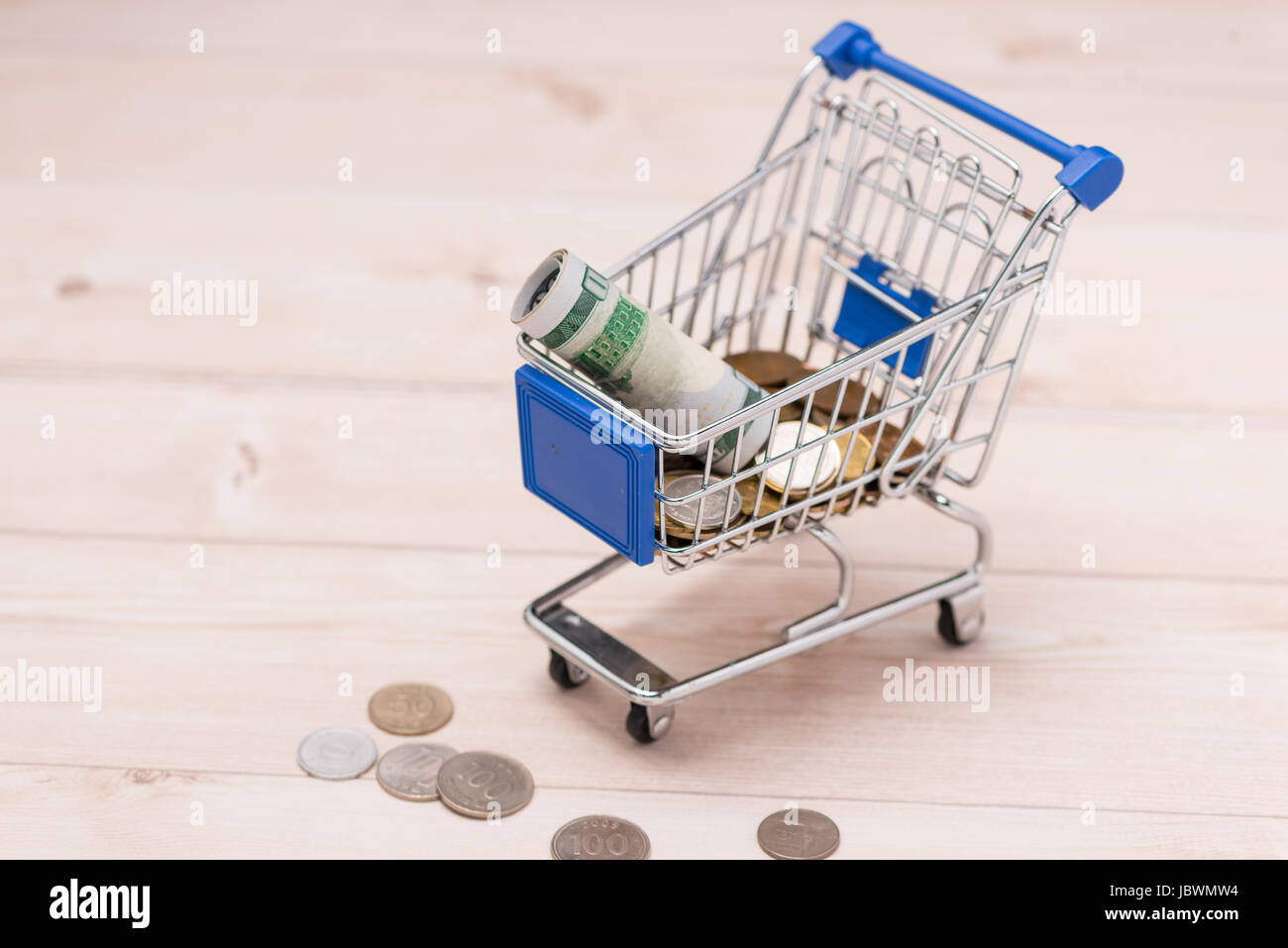 Financial concept. Small trolley and coin on table Stock Photo - Alamy
