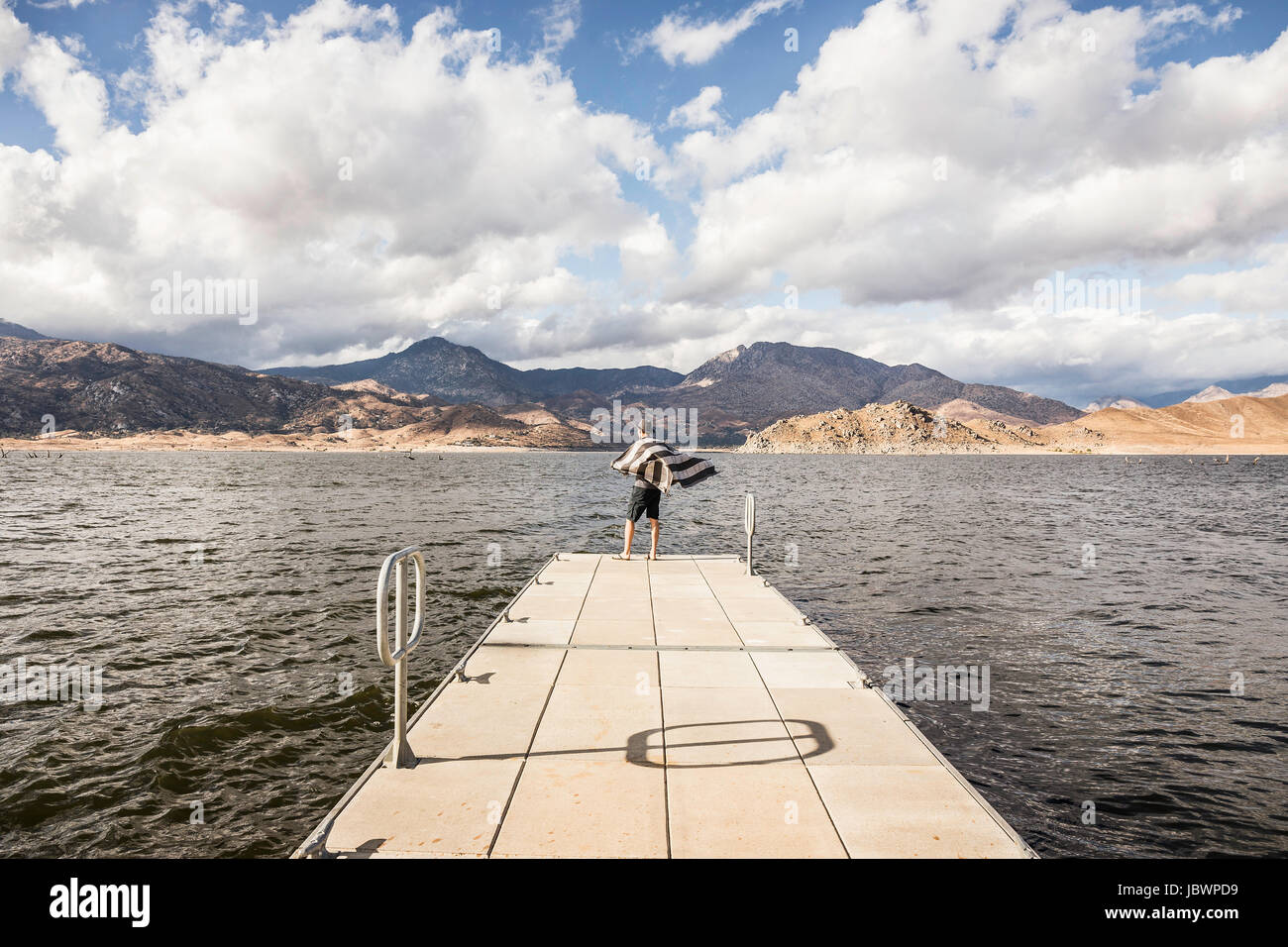 Rear view of man looking out from windy pier on Lake Isabella ...