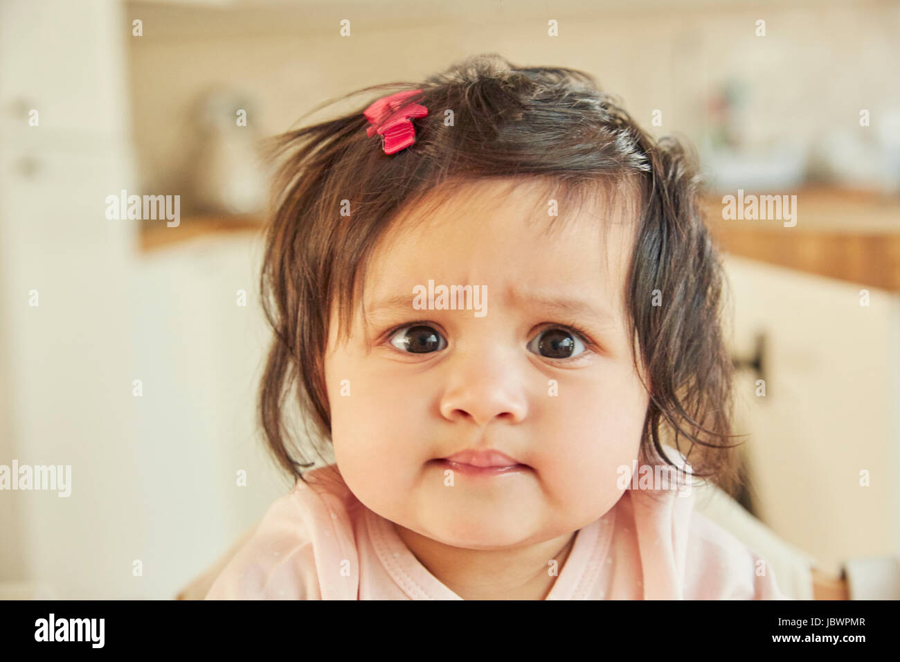 Portrait of cute baby girl pulling a face Stock Photo - Alamy