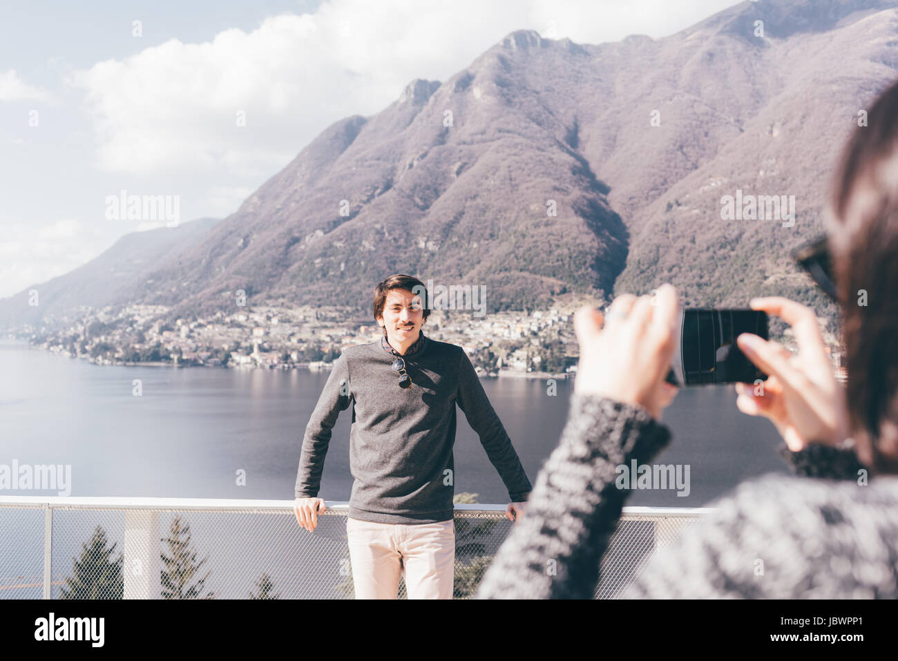 Over shoulder view of woman photographing boyfriend at lakeside, Monte ...
