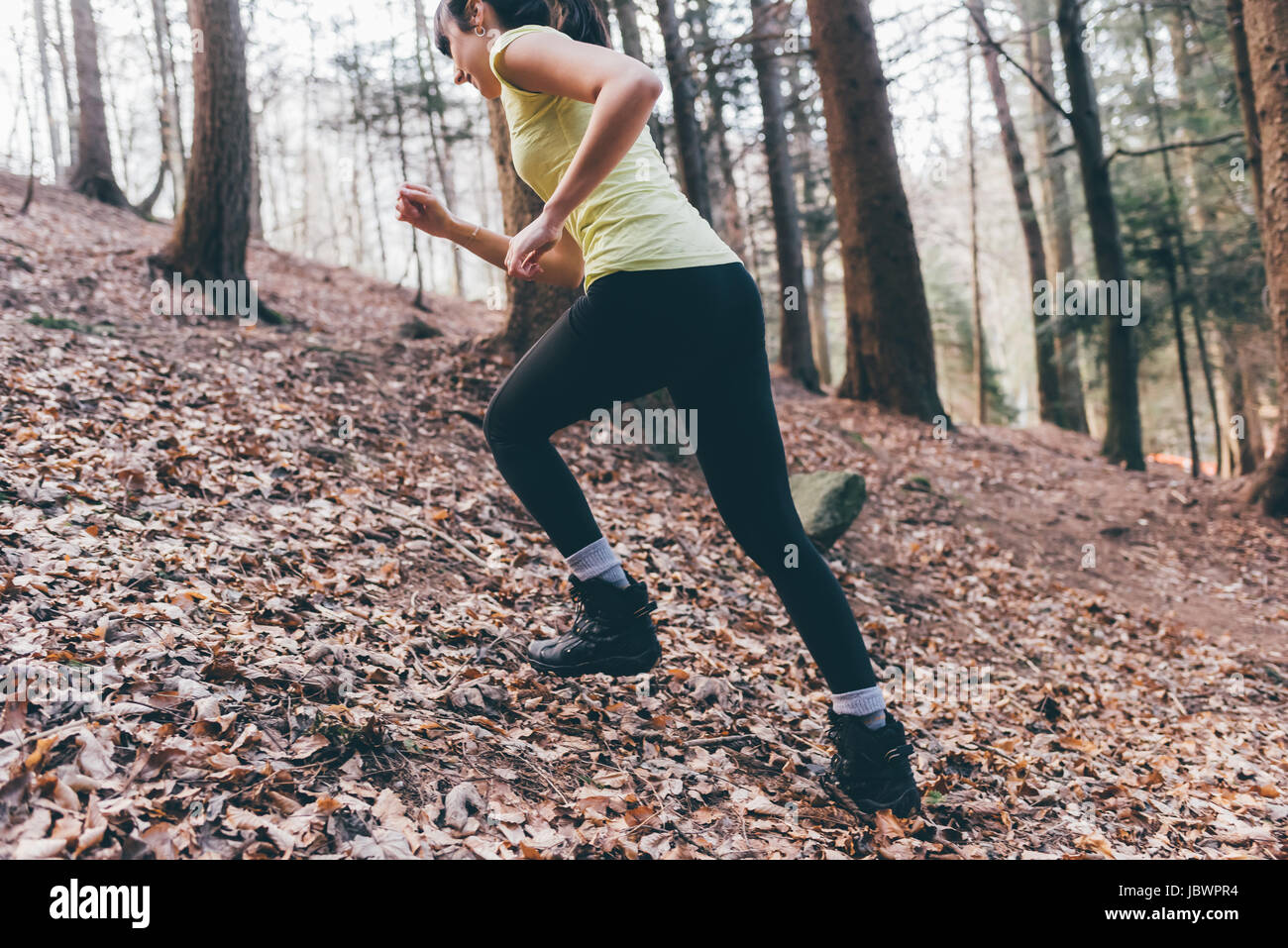 Female runner running up steep forest, Monte San Primo, Italy Stock ...