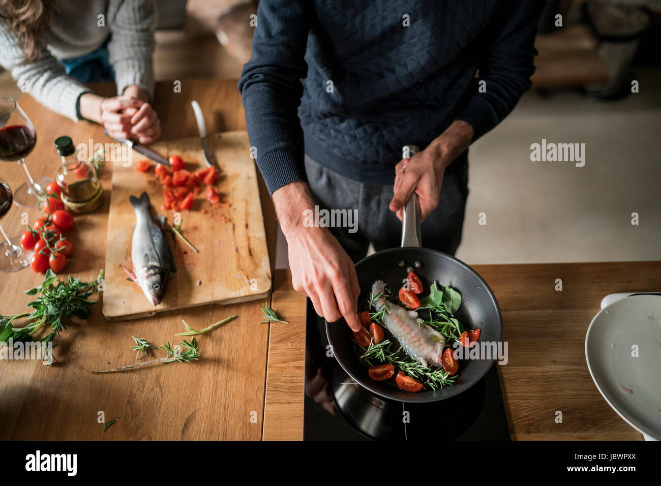 Mid section of young couple preparing fish at kitchen counter Stock ...