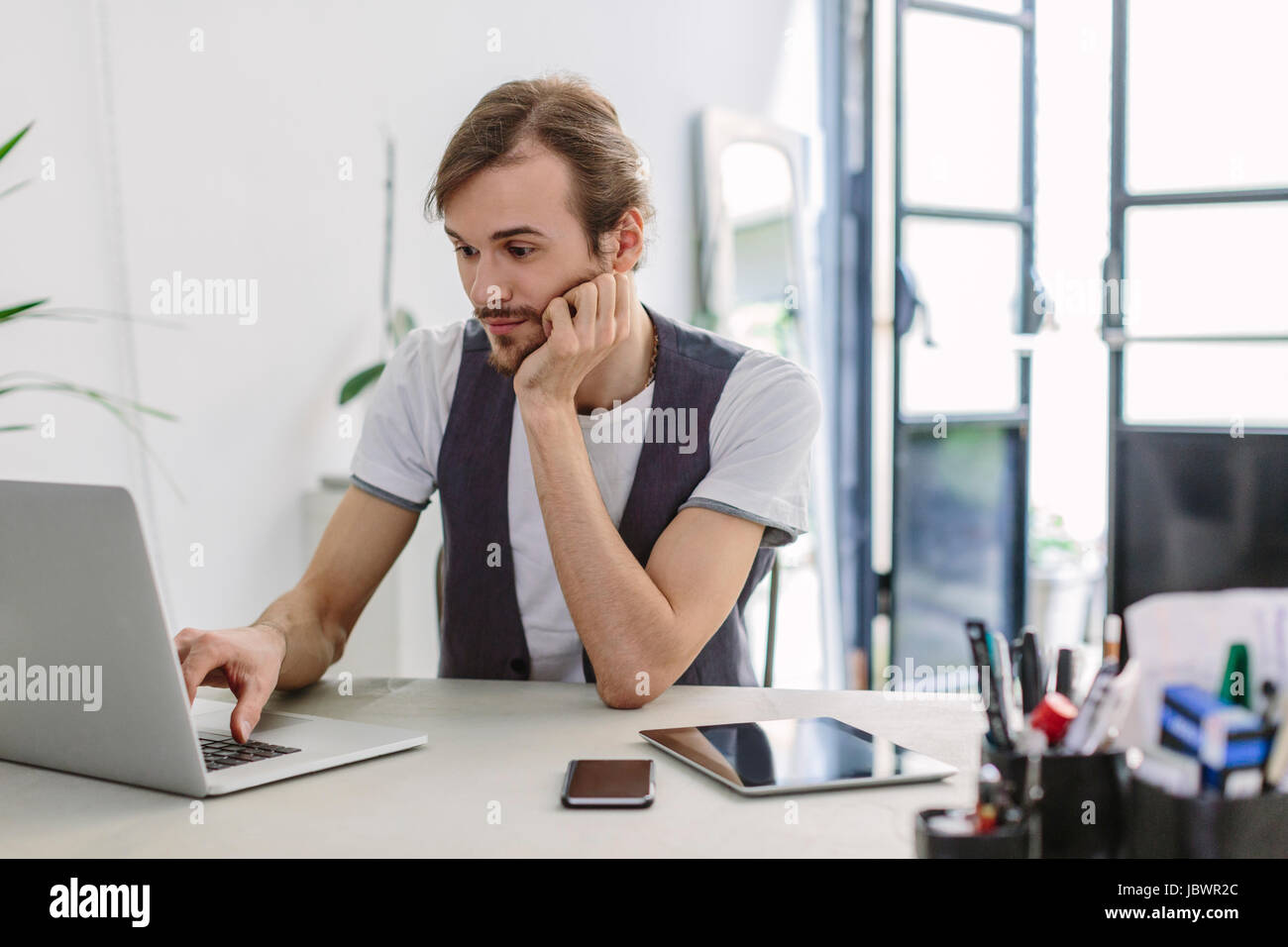 Man at desk using laptop Stock Photo - Alamy