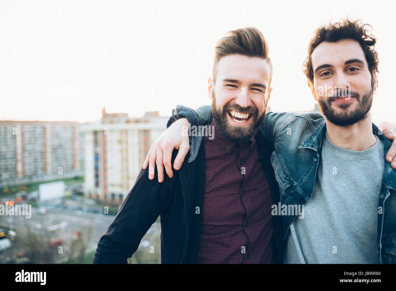 Portrait of two young men, on roof, smiling Stock Photo - Alamy