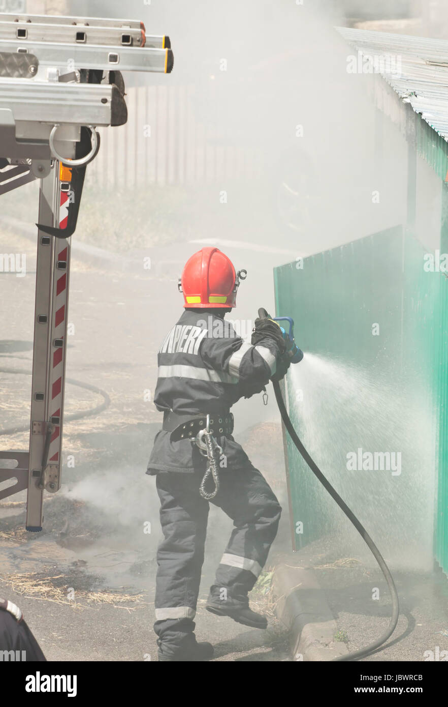 Firefighter in action - Fireman extinguishing a fire Stock Photo - Alamy