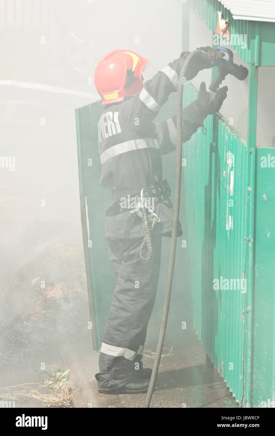 Firefighter in action - Fireman extinguishing a fire Stock Photo - Alamy