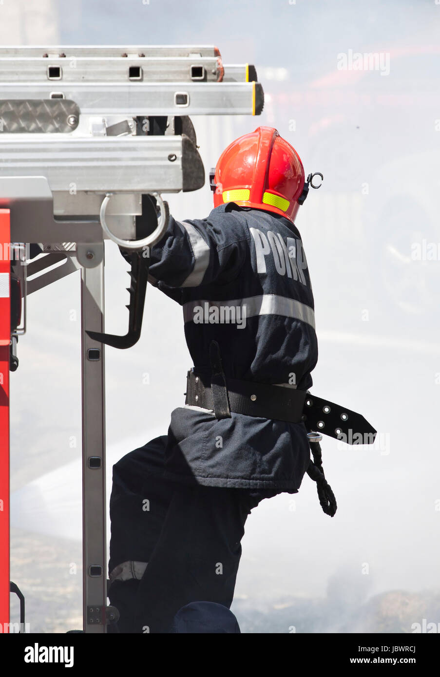 Firefighter in action - Fireman extinguishing a fire Stock Photo - Alamy