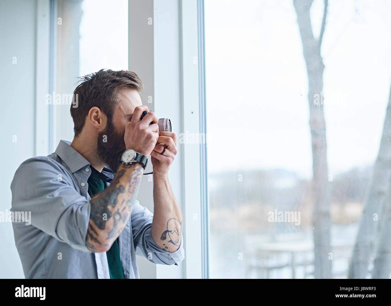 Male designer photographing through design studio window Stock Photo ...