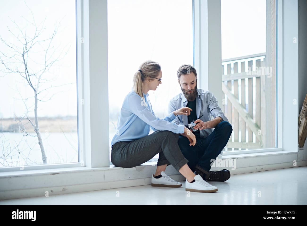 Female and male designers reviewing digital camera photographs in ... Female and male designers reviewing digital camera photographs in ...