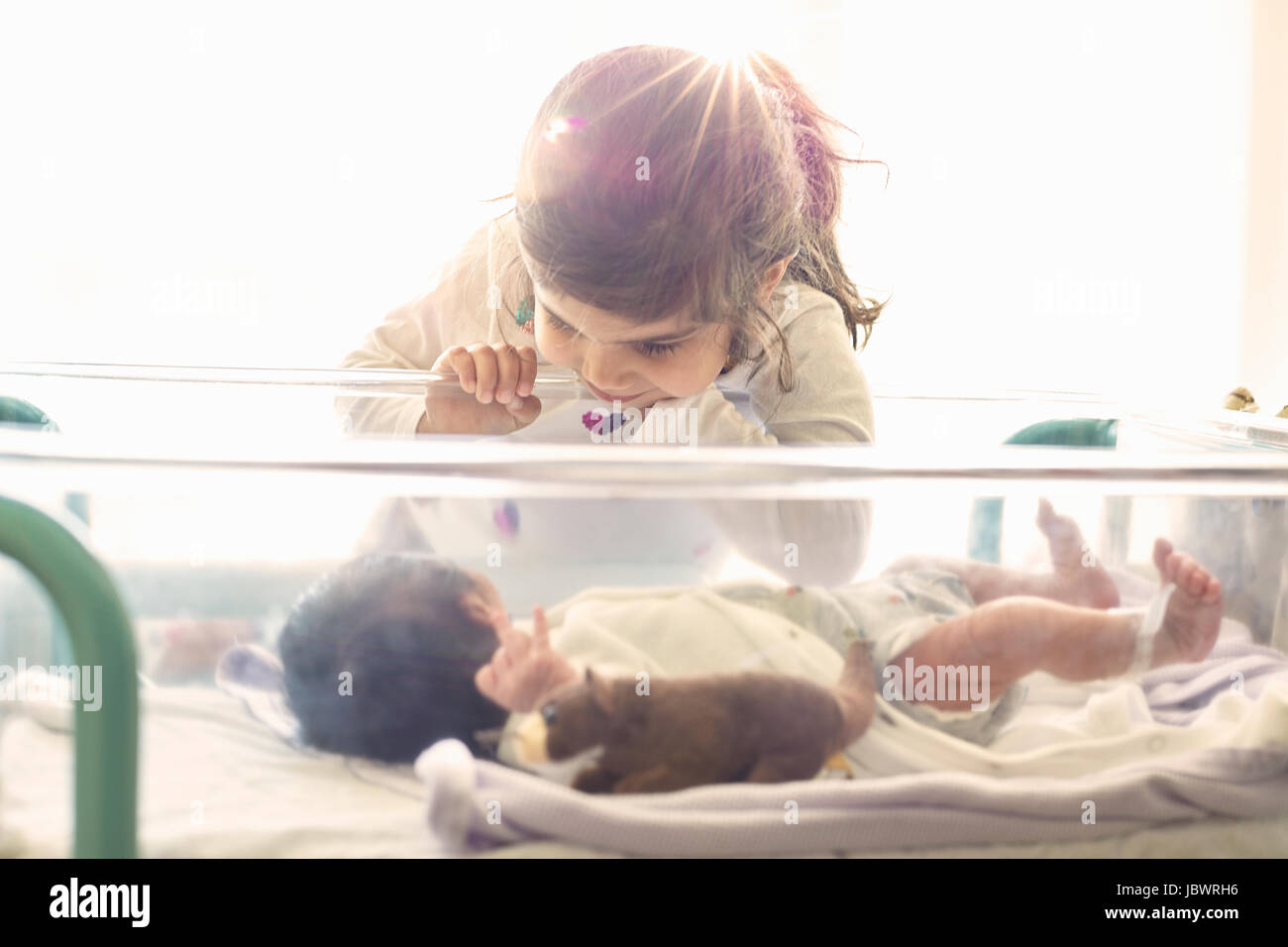 Young girl looking at newborn baby brother Stock Photo - Alamy