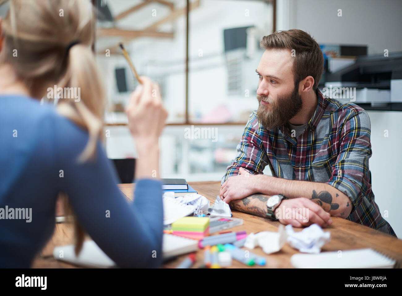 Female and male designers at design studio desk meeting Stock Photo - Alamy