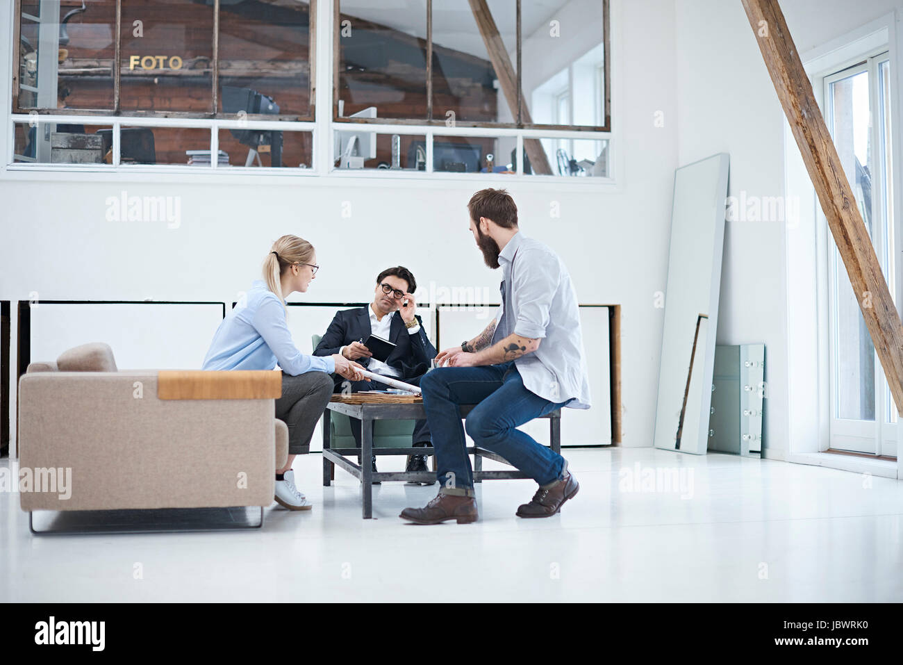 Design team meeting on design studio sofa Stock Photo - Alamy